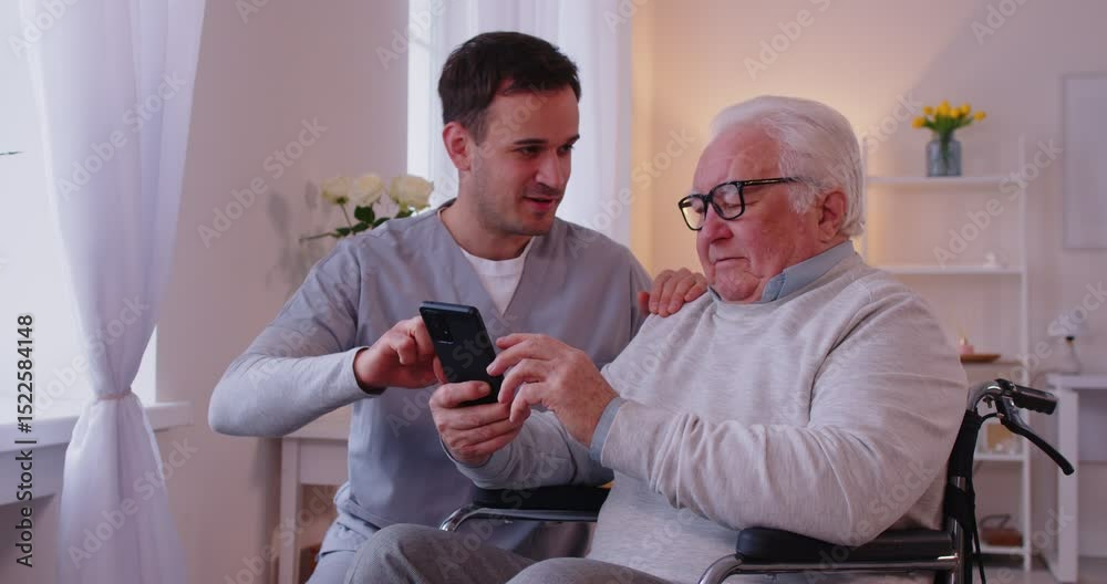 Male caregiver or social worker teaching senior man with disability in ...