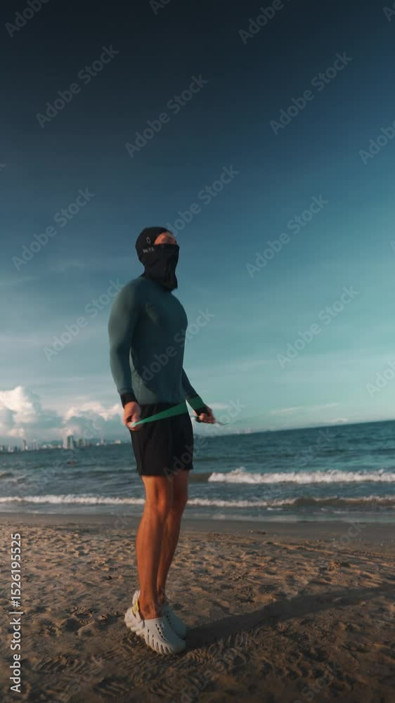 Man bodybuilder jumping rope at sea beach during sunset workout ...