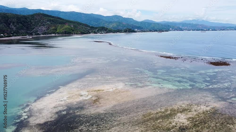Aerial view reversing over ocean during low tide with sand bars in ...