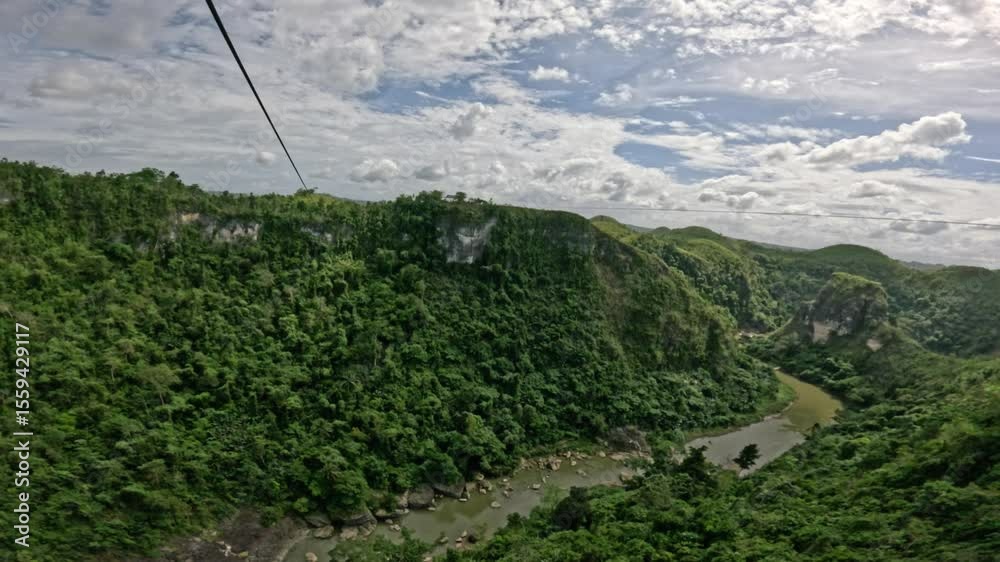 Tropical canyon scenery captured from zipline ride above lush forest in ...