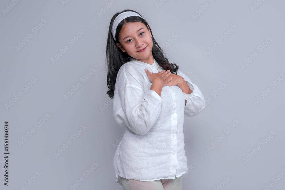 Poster Portrait of a young Asian woman smiling sincerely with both ...