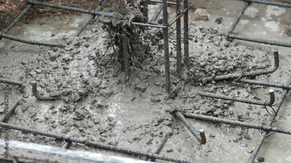 Liquid concrete flowing into metal reinforcement cage, forming robust ...