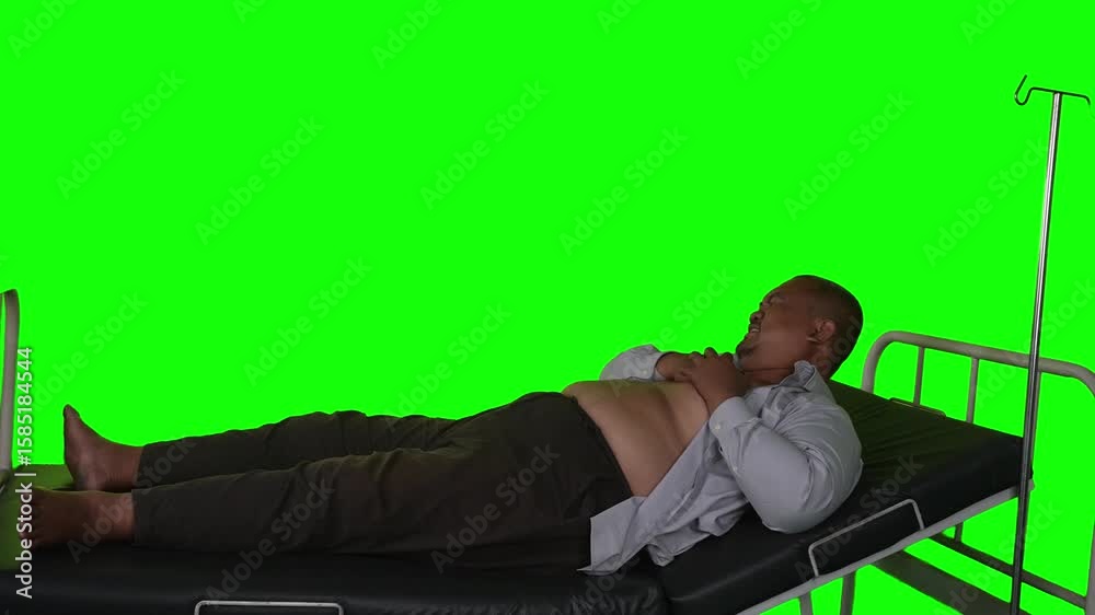 Overweight man lying on hospital bed during medical examination with ...