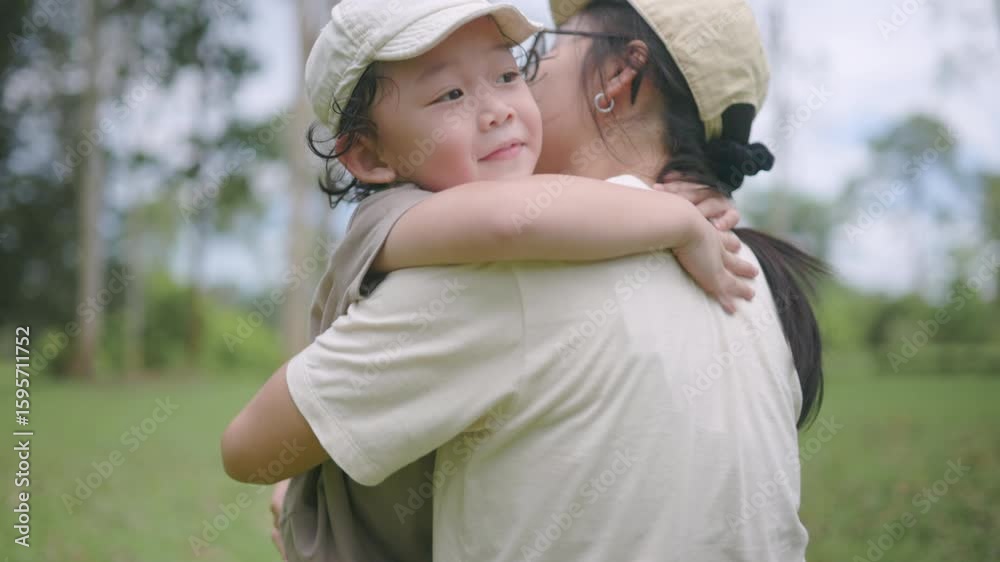 Asian mom and son share a warm hug with laughter. A candid scene of ...