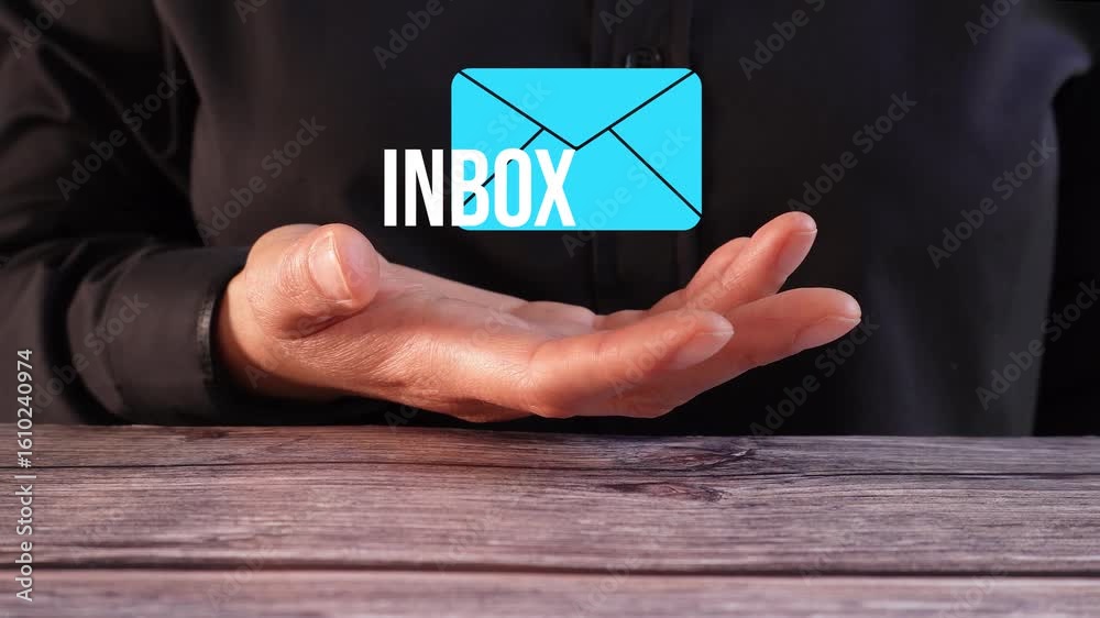 Person's hand with a table holding an icon of a blue envelope with the ...