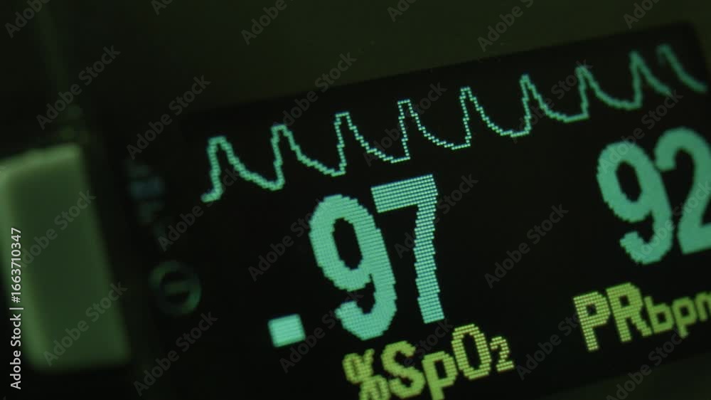 Pulse oximeter showing oxygen saturation and heart rate on screen ...