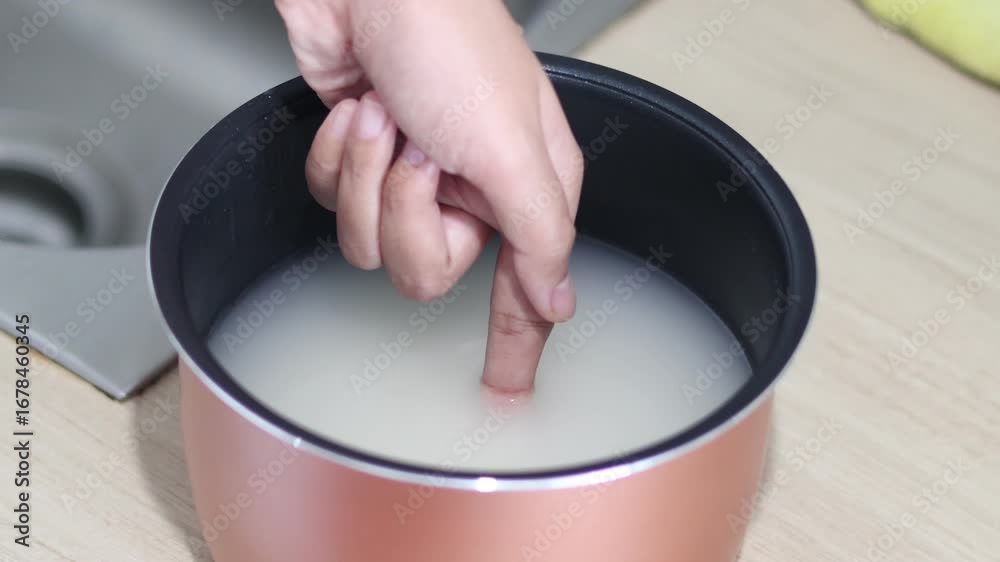 How to cook rice. Use your finger to measure the water level when ...