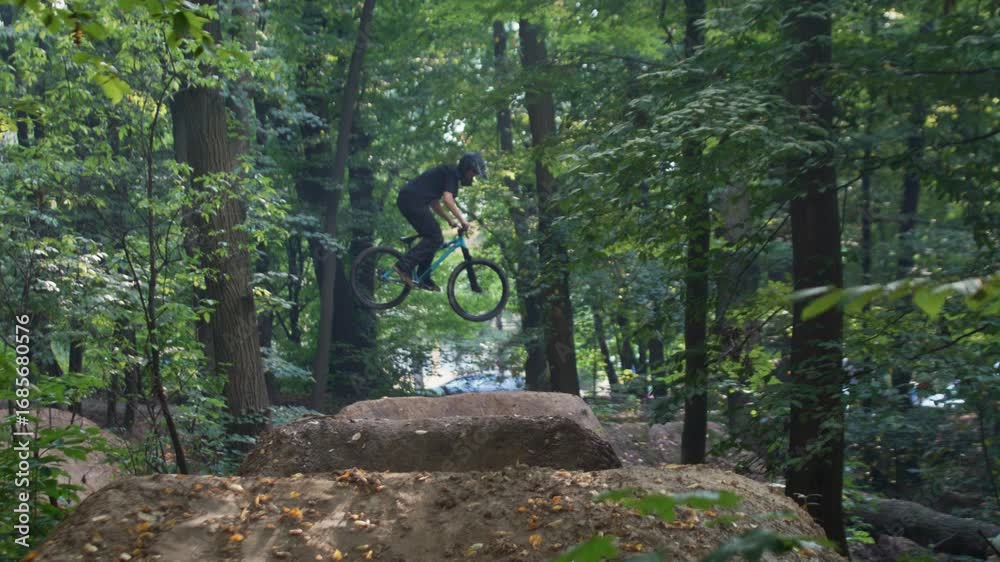 Athlete shows tailwhip and 360 tricks on bike jumping over hills Stock ...