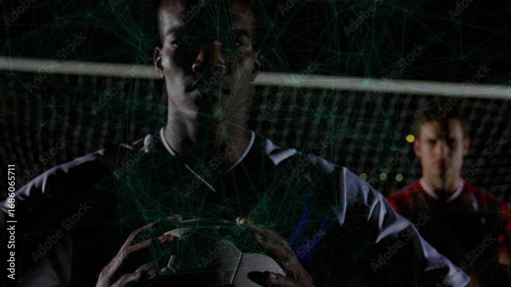 Goalkeeper gripping ball camera pulling back at night revealing ...
