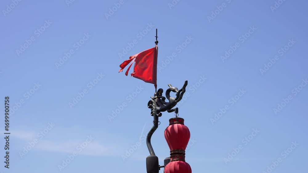 Red Flag and lanterns wave in wind on statue along ancient Xian City ...