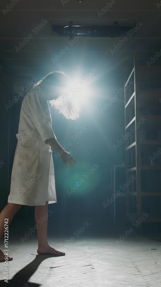 Zombie woman in dirty hospital gown stands in corridor stops turns head ...