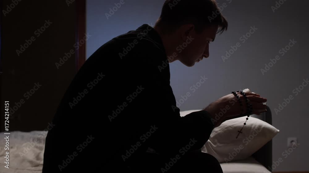 Priest reading holy book and holding rosary beads in dark room Stock ...
