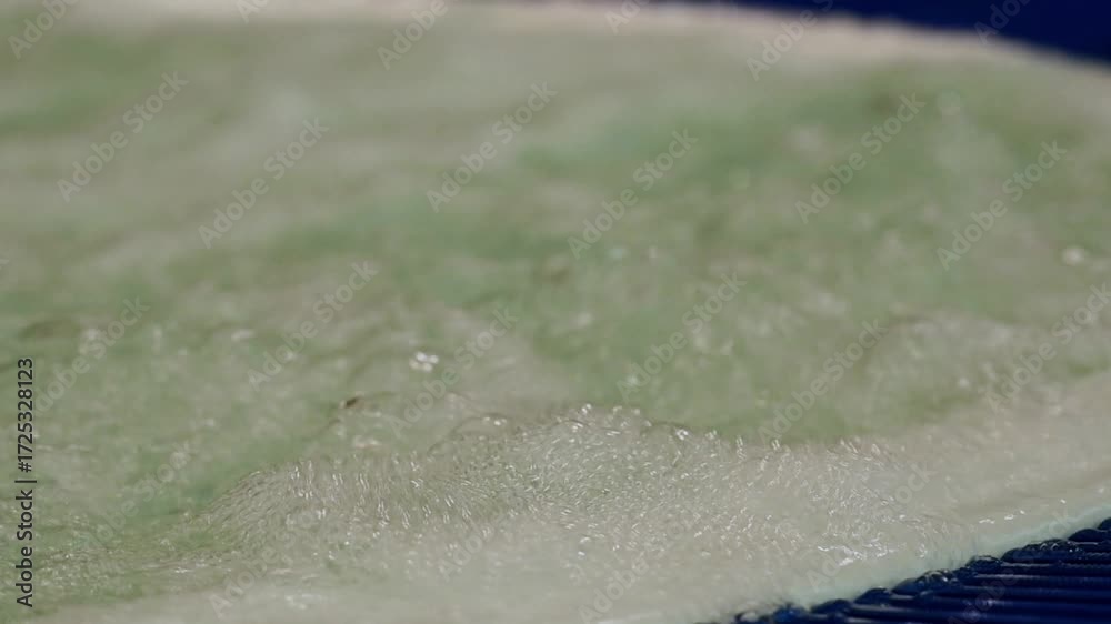 Water churns violently in jacuzzi, bubbles erupting and collapsing in ...