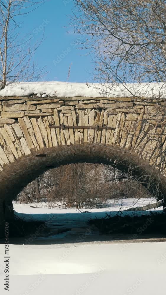 An old stone arch bridge, where the stones in the arch are laid in a ...