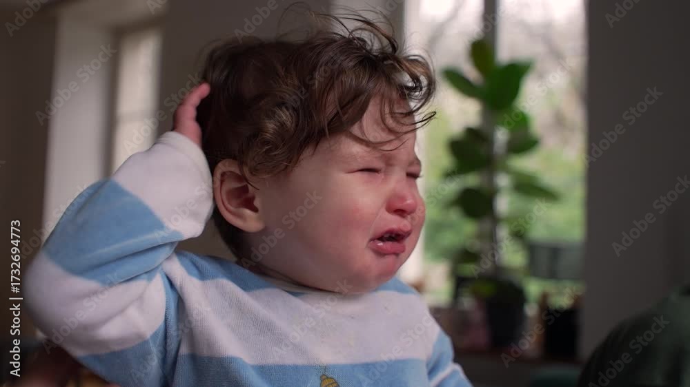 Close up of baby crying with hand reaching to wipe nose, emotional ...