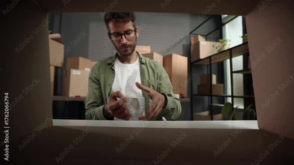 A man is opening a box and pulling out a bubble wrap 素材庫影片 | Adobe Stock