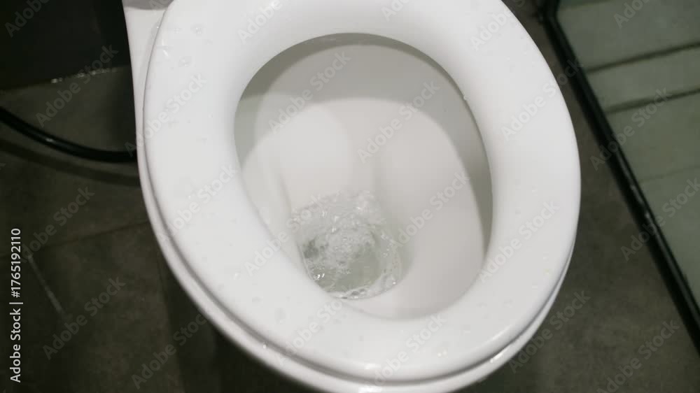 Flushing the toilet on a modern toilet in the bathroom after use ...