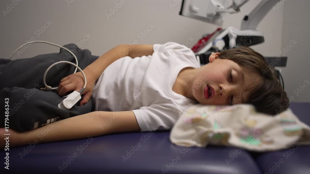 Young boy lying in hospital bed struggling to breathe during asthma ...