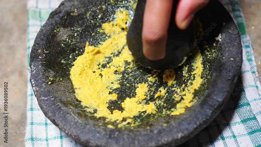 Hand Grinding Yellow Spice Paste in Traditional Stone Mortar and Pestle ...