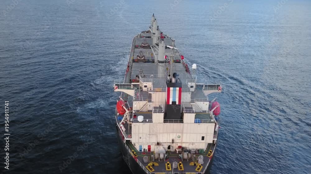 Rear deck of bulk carrier ship heading towards open sea. Bulkers are ...