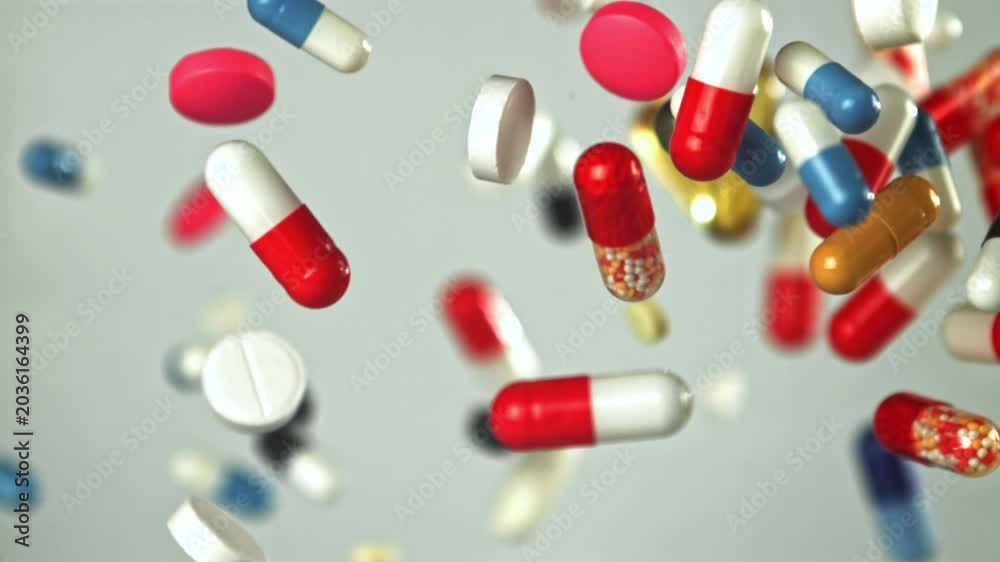 Assorted colorful capsules and tablets drifting in pale space, product ...