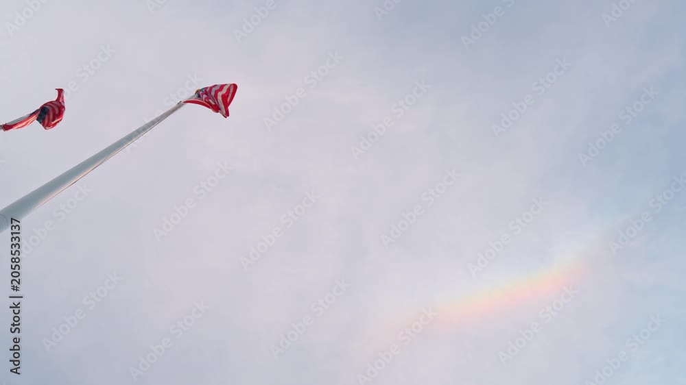 Poles with American flags flapping in the wind. Low angle view ...